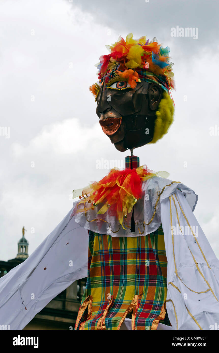 A tall, colourful puppet character taking part in the Cavalcade, part ...