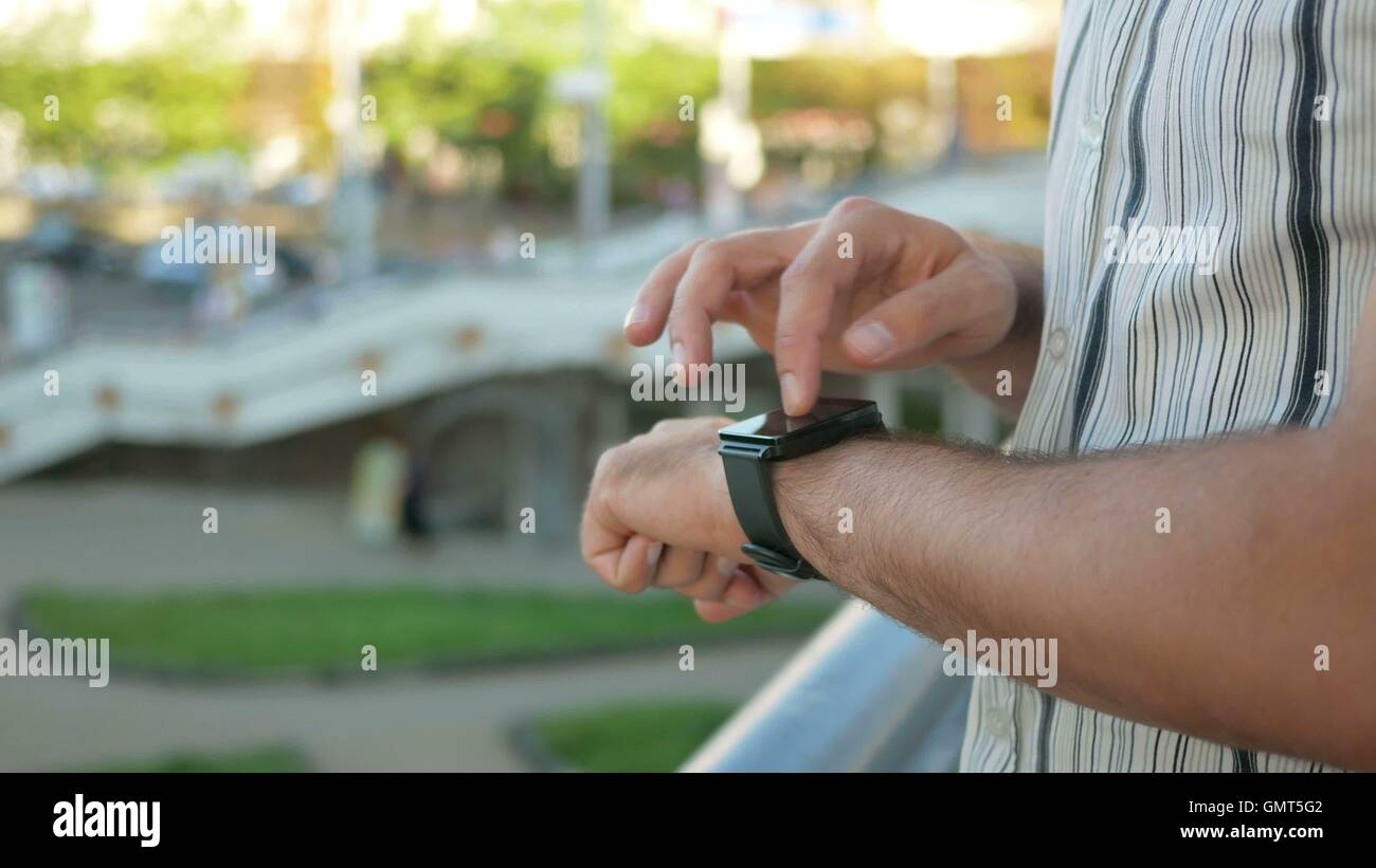 Outdoor portrait of modern young man with smart watch in the street ...
