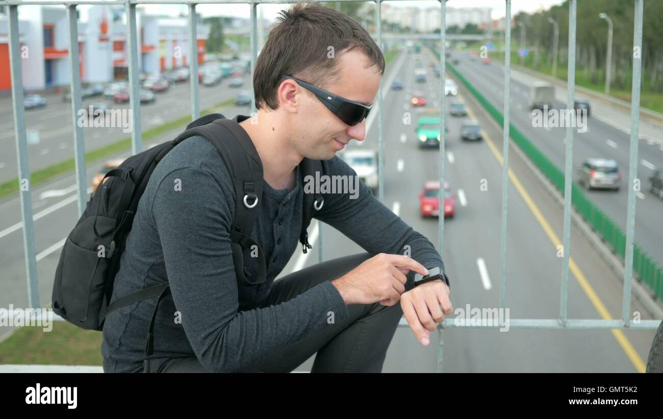 Outdoor portrait of modern young man with smart watch in the street ...