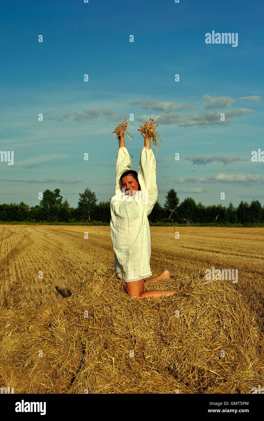 girl in traditional Russian costume sitting on a haystack Stock Photo ...
