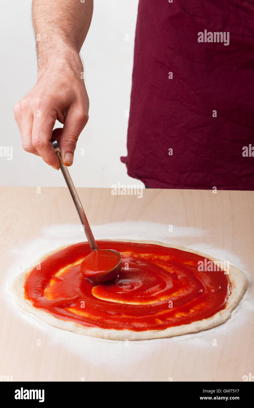 pouring tomato sauce on a pizza Stock Photo - Alamy