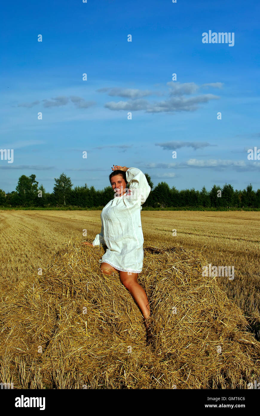 girl in traditional Russian costume sitting on a haystack and smiling ...