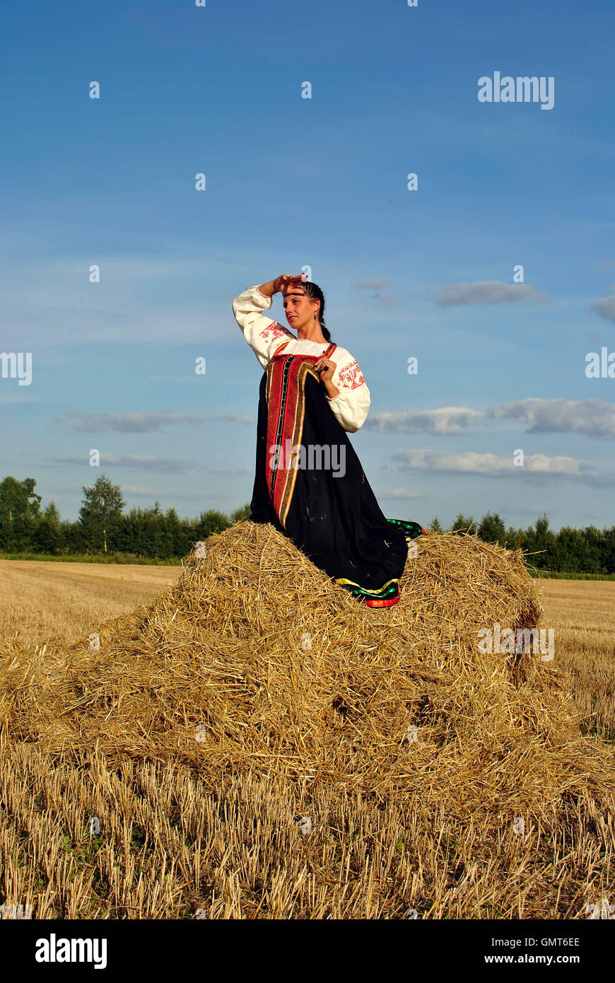 girl in traditional Russian costume sitting on a haystack Stock Photo ...