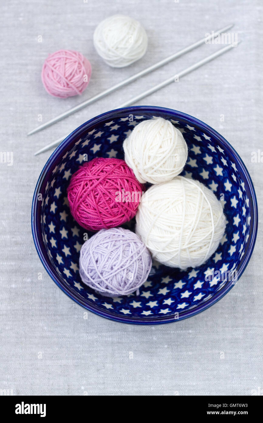 Bright balls of yarn and knitting needles on a plate Stock Photo - Alamy