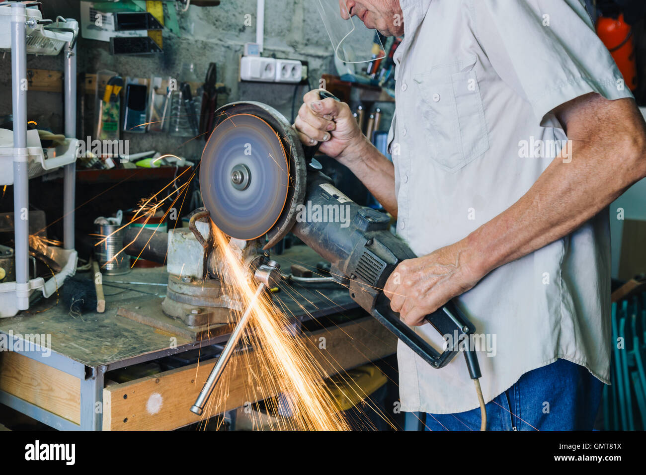 Senior man working with angle grinder Stock Photo - Alamy
