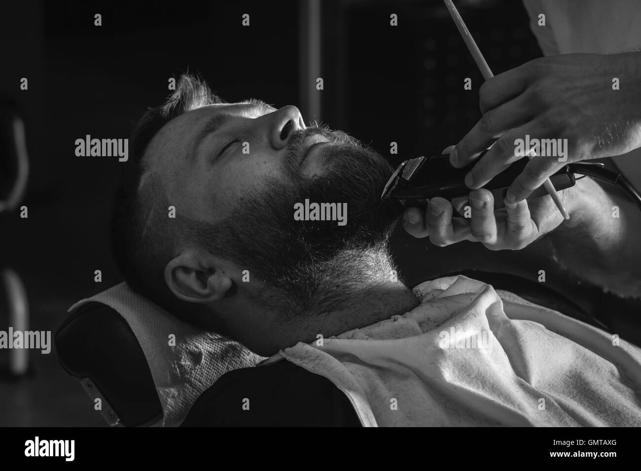 Barber cutting beard caucasian male Black and White Stock Photos ...