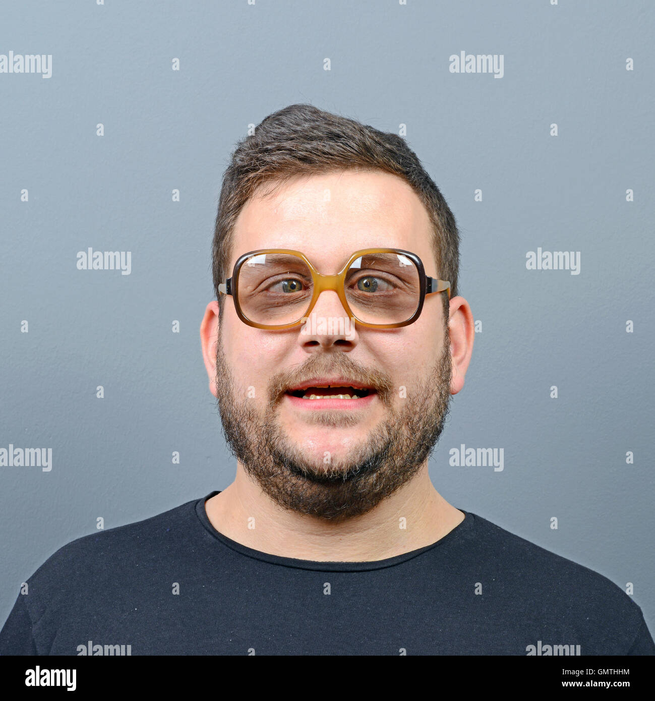 Portrait of a confused chubby geek against gray background Stock Photo ...