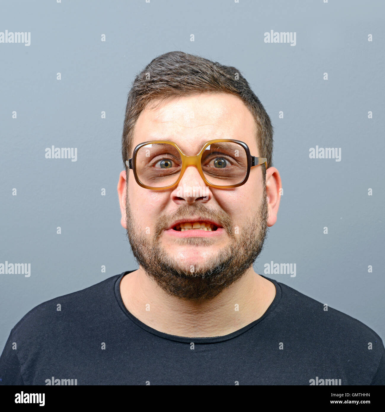 Portrait of a confused chubby geek against gray background Stock Photo ...