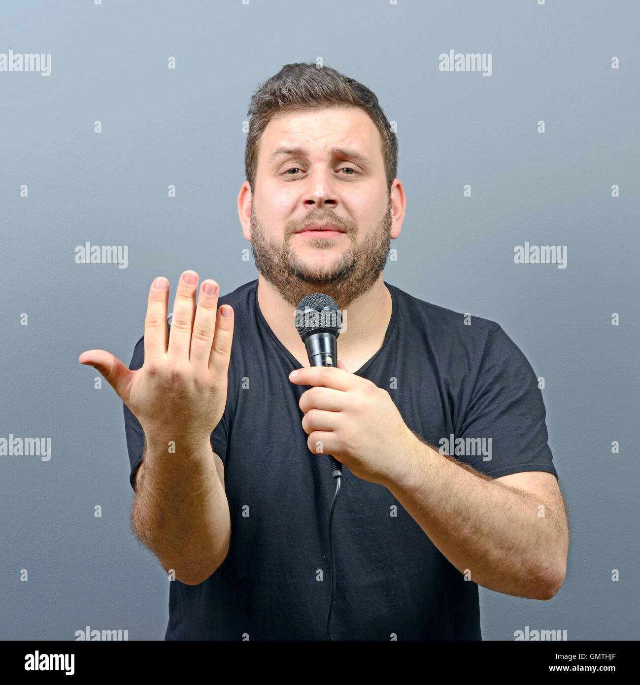 Portrait of attractive young man singer against gray background Stock ...