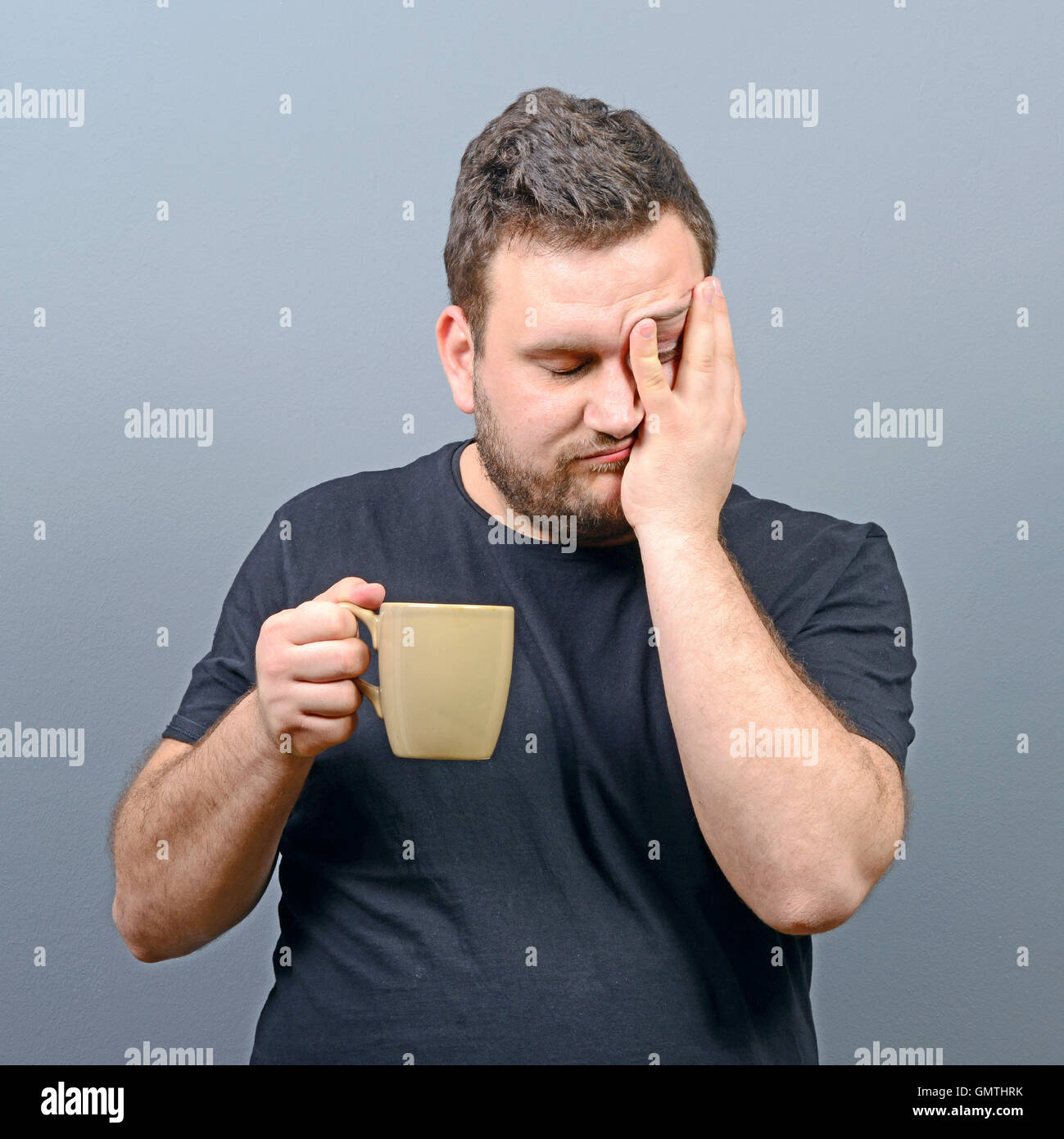 Portrait of tired man having first morning coffee and still speepy ...