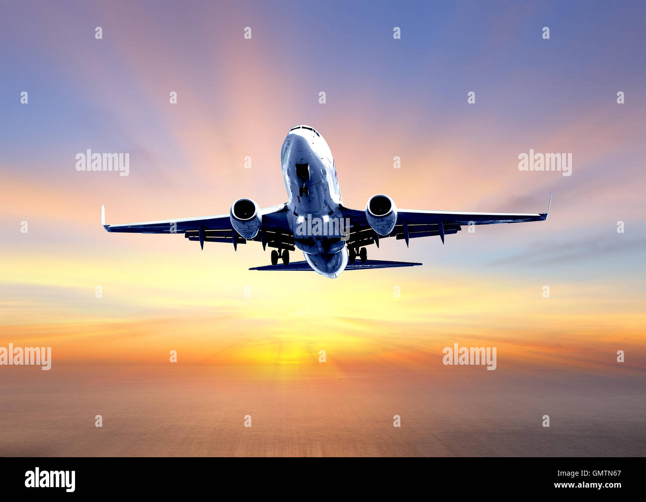 Place flying in sunset sky Stock Photo - Alamy