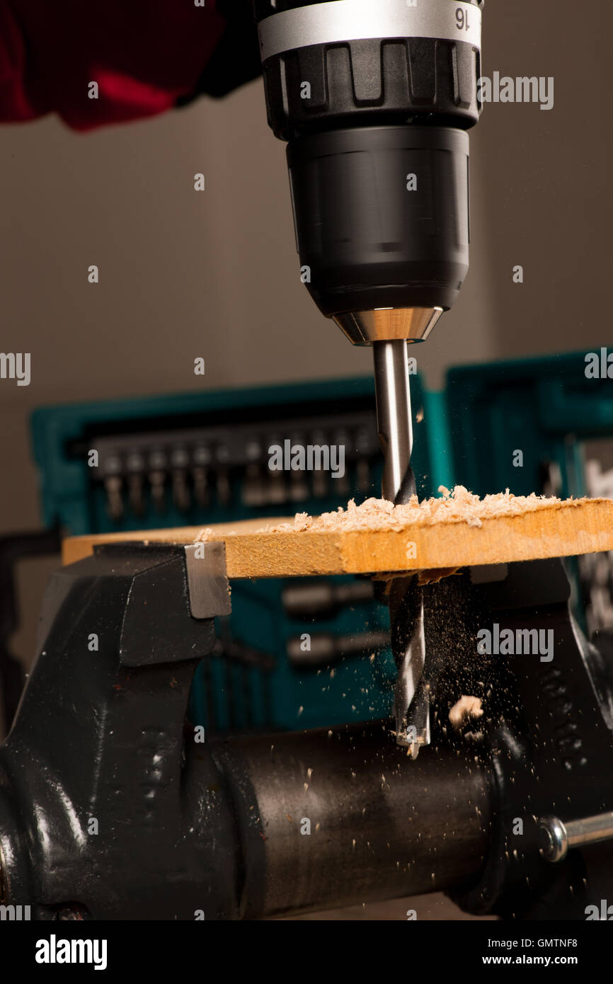 Image of drilling hole with screwdriver in wood clamped in vice tool ...
