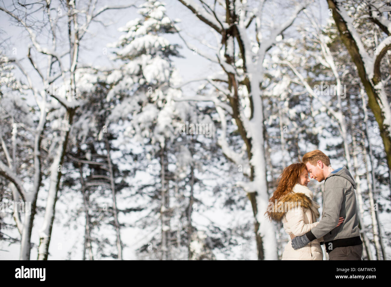Loving young couple at winter forest Stock Photo - Alamy