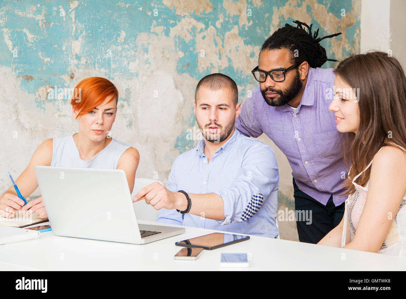 Young people working by the desk in the grunge office Stock Photo - Alamy