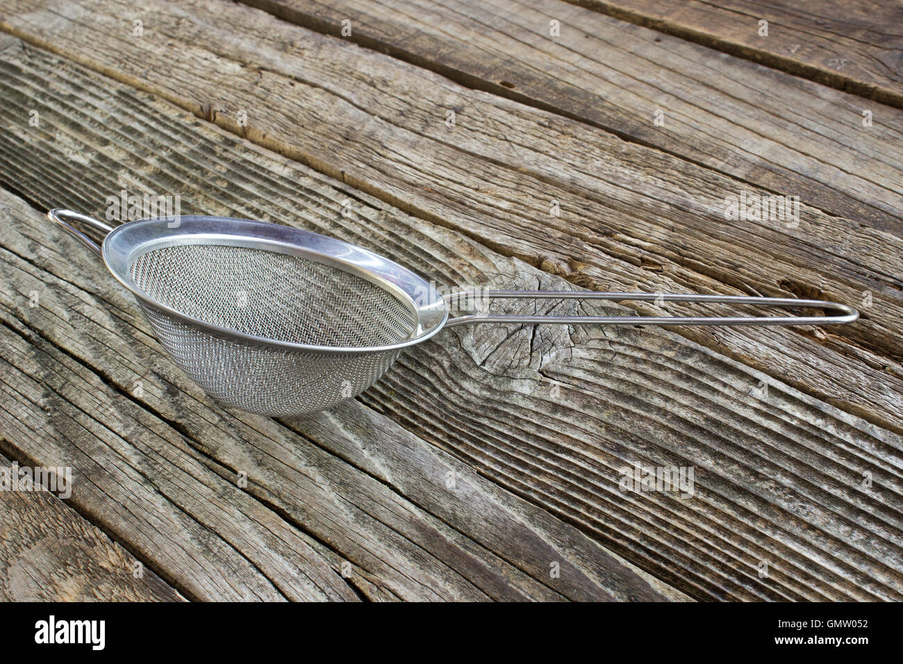 Colander on wooden background Stock Photo - Alamy