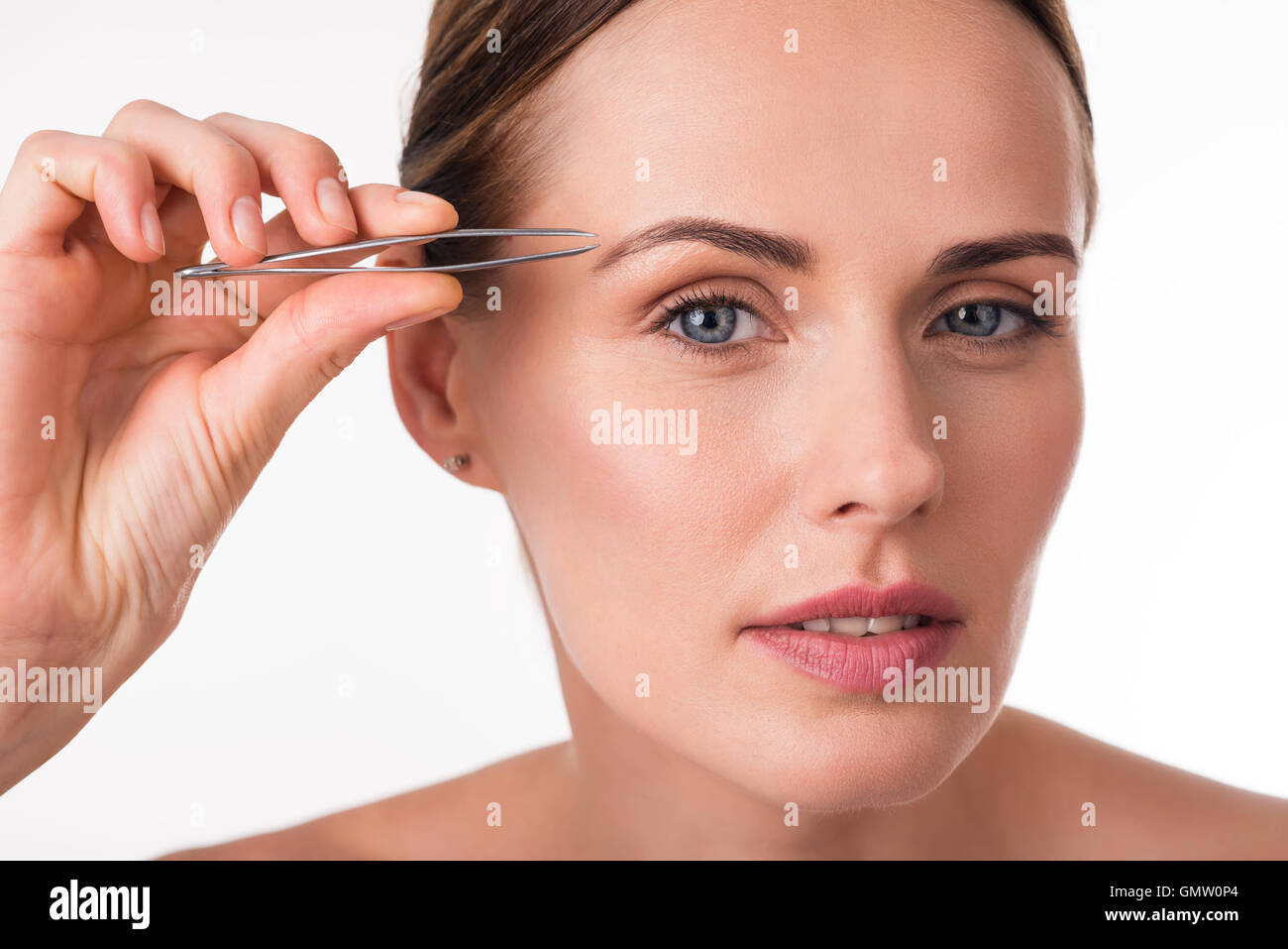 Pretty young woman using tweezers Stock Photo - Alamy