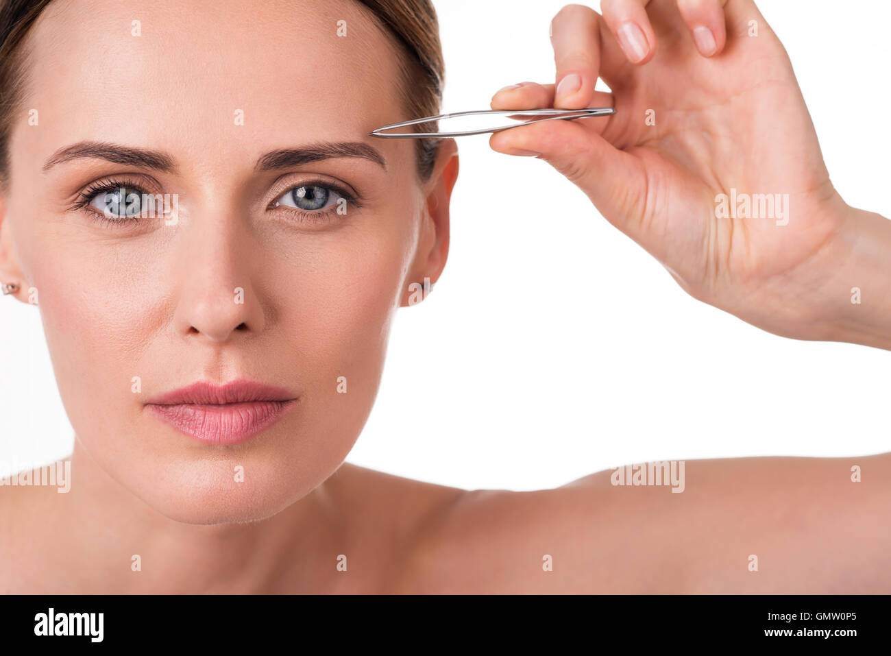 Beautiful young woman using tweezers Stock Photo - Alamy