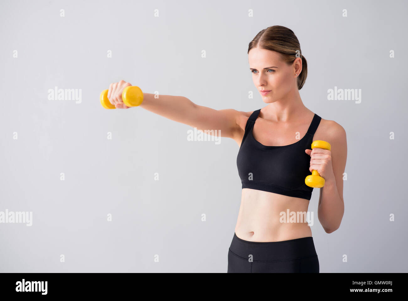 Beautiful young woman with dumb bells Stock Photo - Alamy