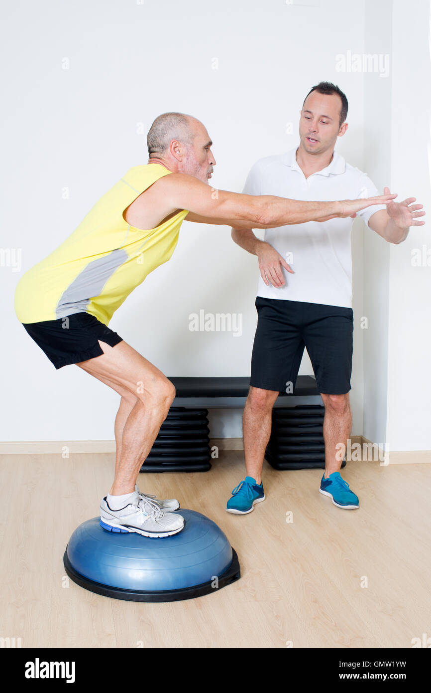 personal trainer explaining exercise on blanace platform Stock Photo ...