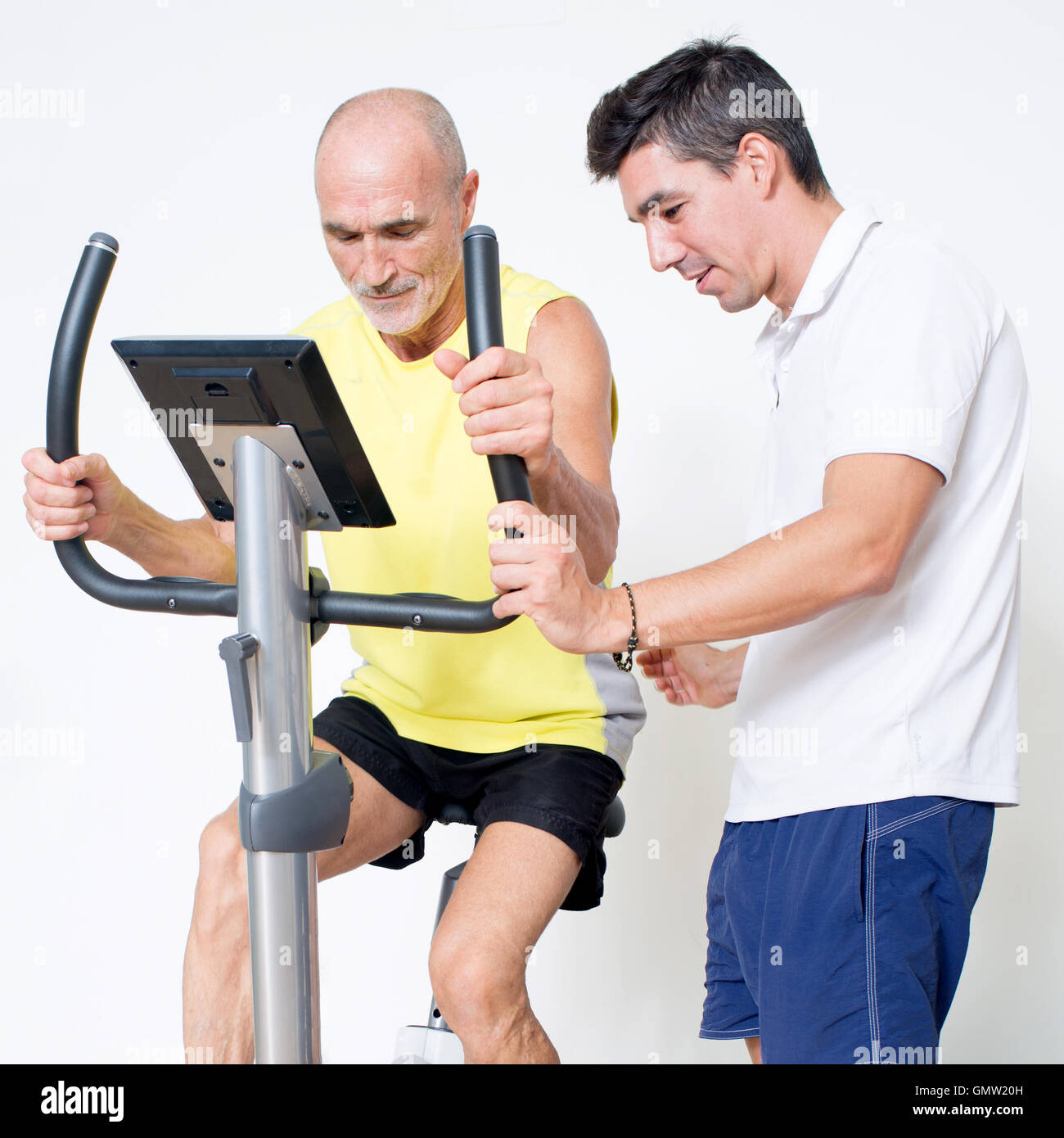 Personal trainer correcting spinning exercise Stock Photo - Alamy