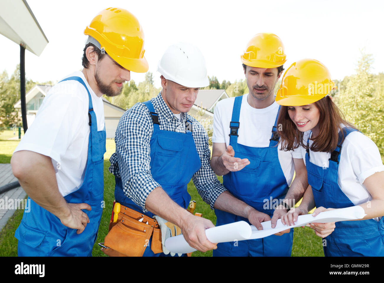 Team of builders with construction plan outdoors Stock Photo - Alamy