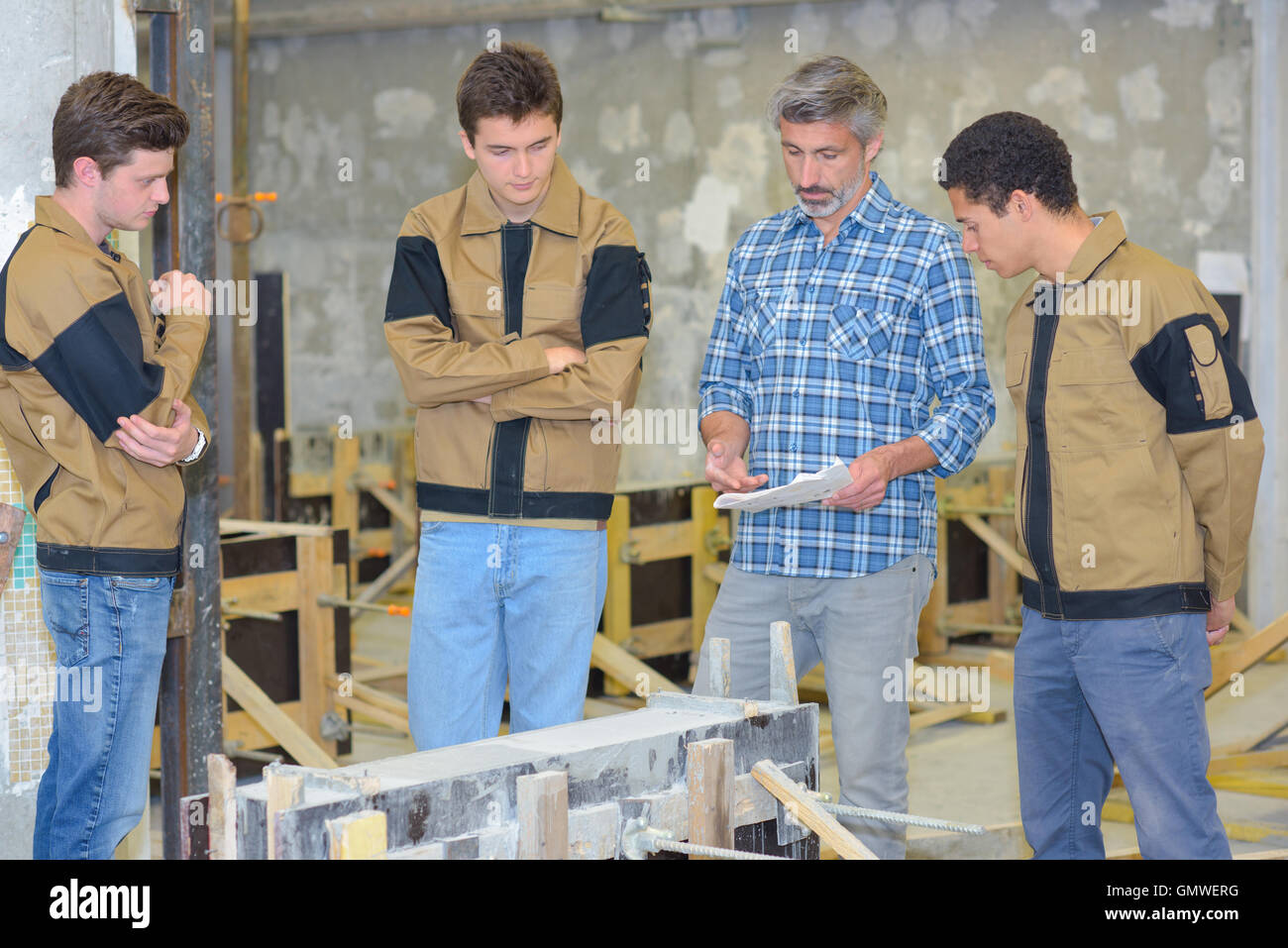 Teacher with three students in practical class Stock Photo - Alamy