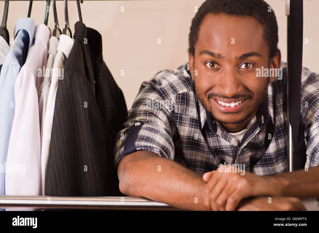 Headshot handsome young man standing inside wardrobe with clothes ...