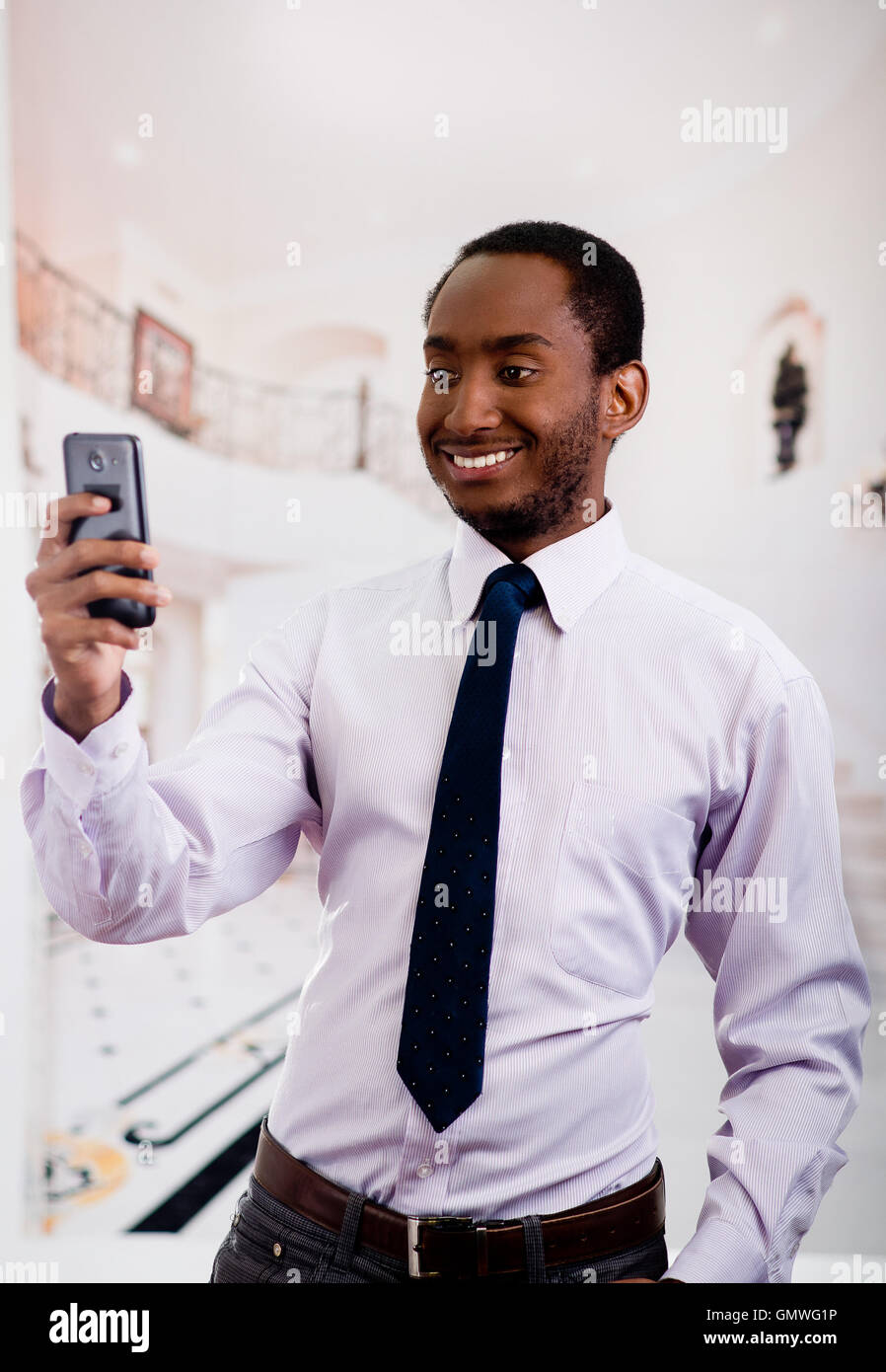 Handsome Man Wearing Shirt And Tie Holding Up Mobile Phone Posing While