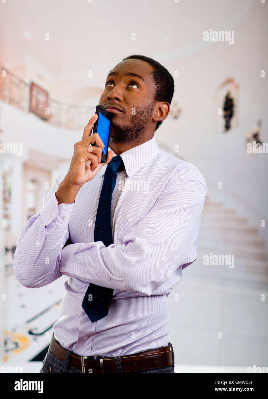 Handsome man wearing shirt and tie posing holding mobile phone in hand ...