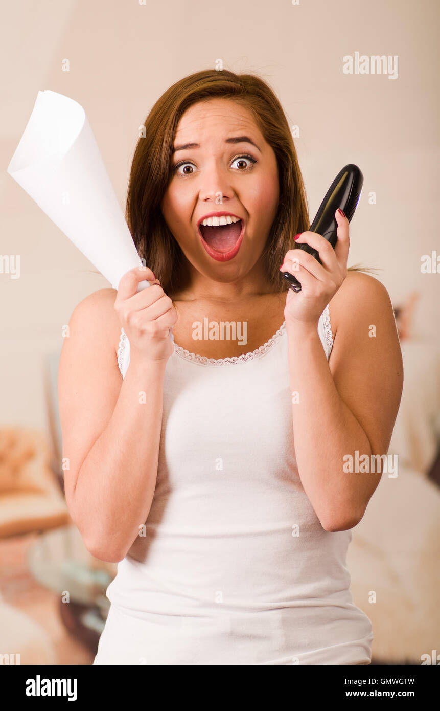 Young woman wearing white top facing camera while screaming in ...