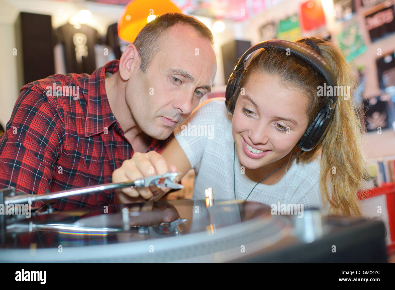 Man watching lady play vinyl record Stock Photo - Alamy