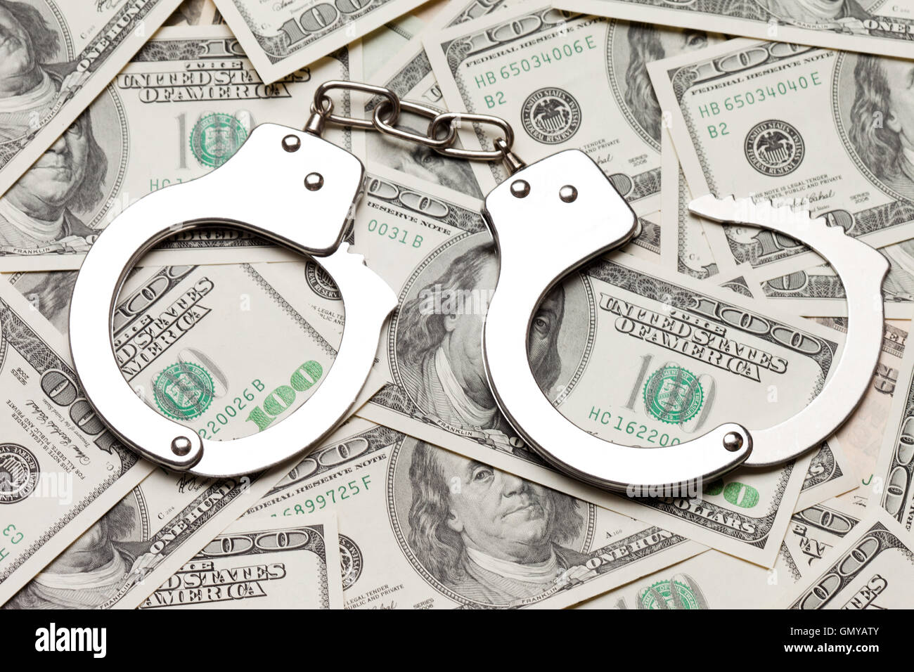 Handcuffs on dollar currency Stock Photo - Alamy