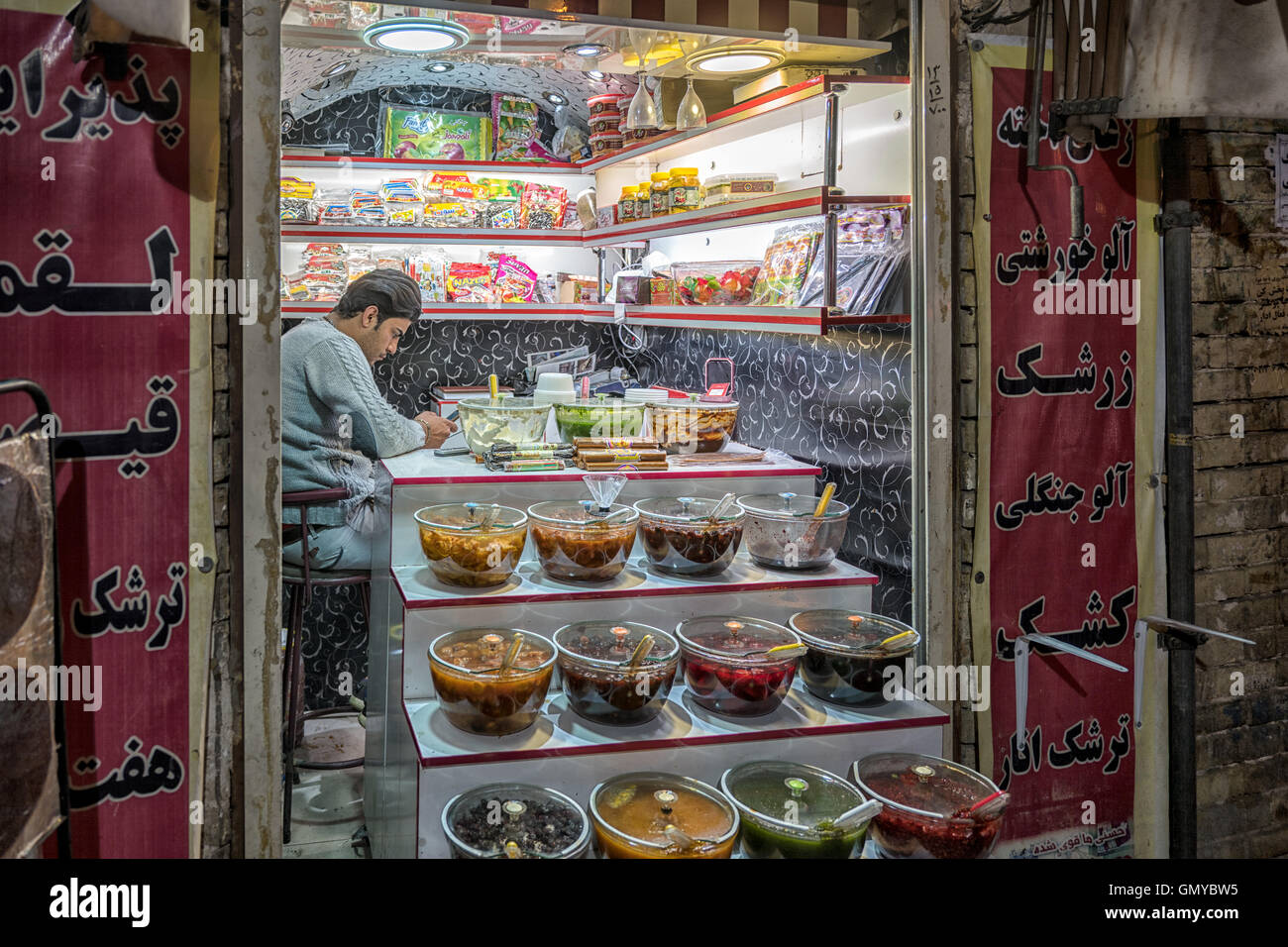 Iranian vendor selling sweets and jams from a street stand at night in ...