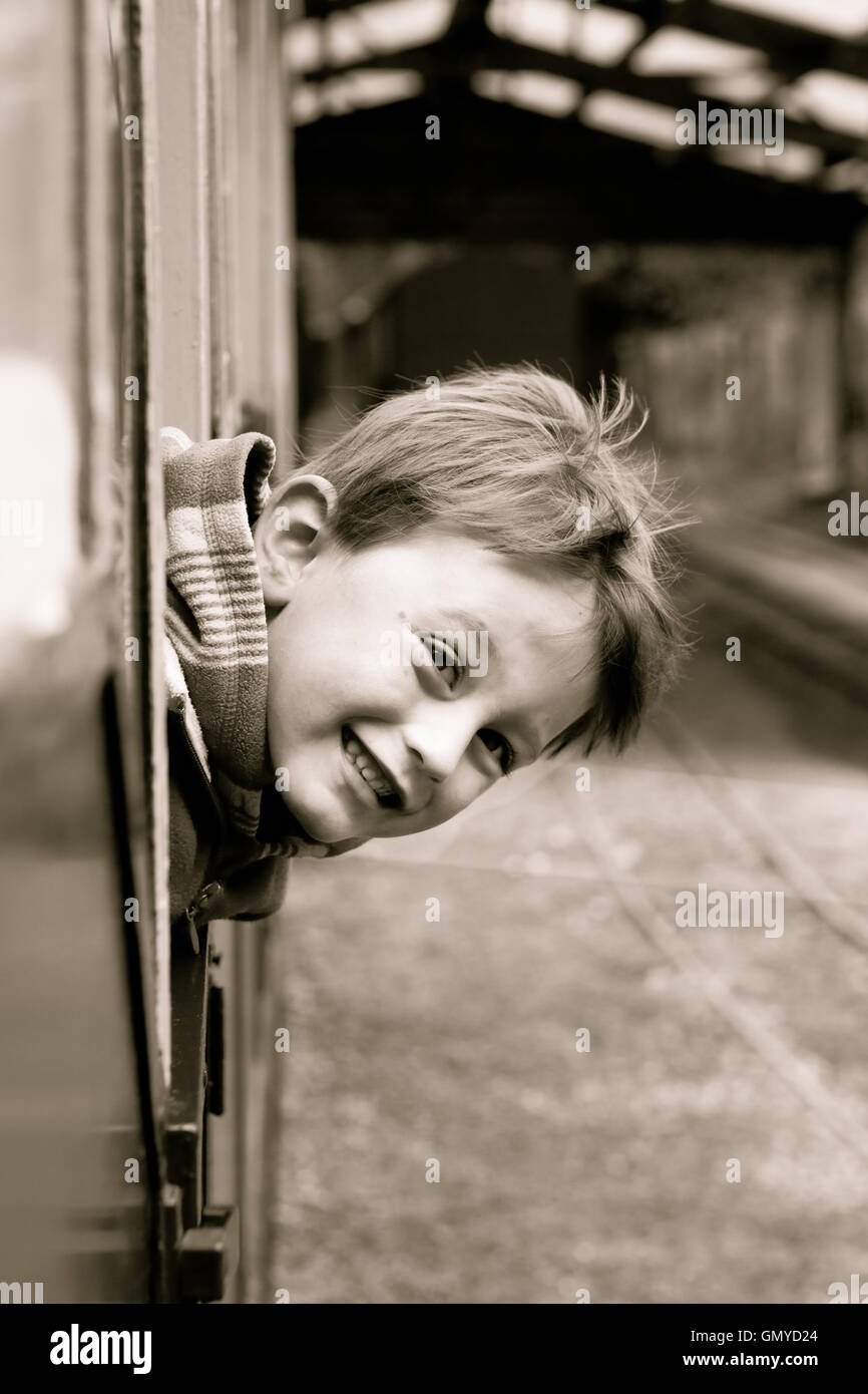 Little boy leaning out of a train window Stock Photo - Alamy