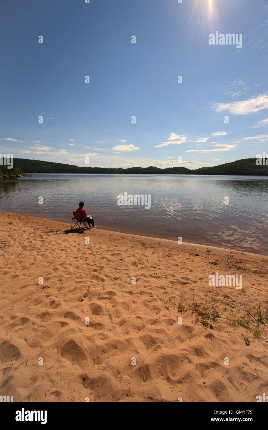 Alone on the Beach of a Calm Wilderness Lake Stock Photo - Alamy