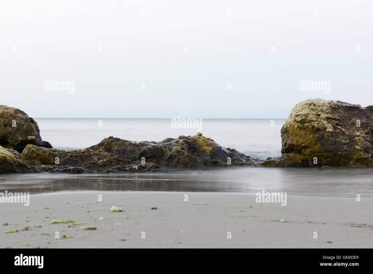 stones on the beach under the incoming wave Stock Photo - Alamy