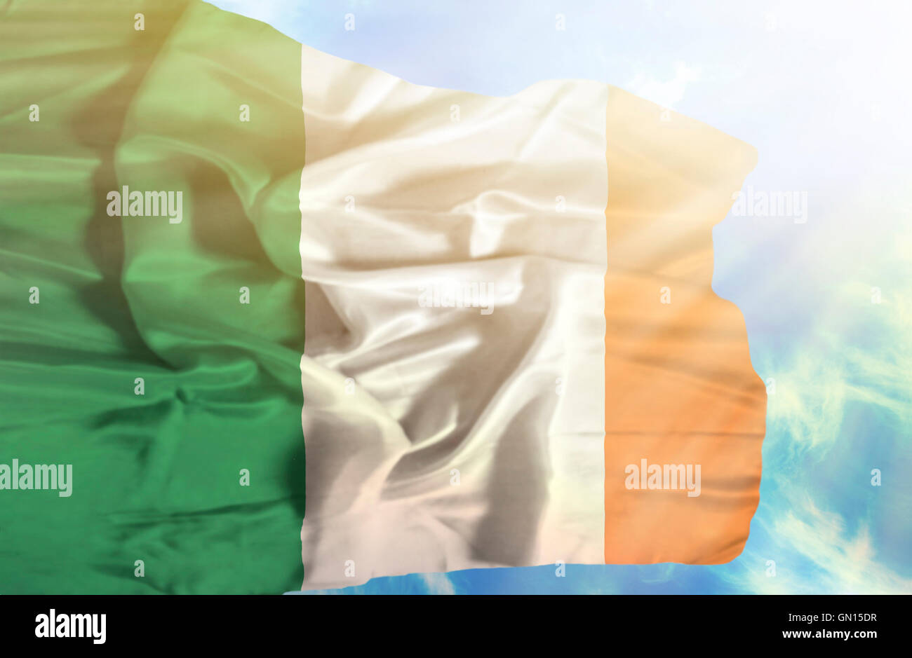 Ireland waving flag against blue sky with sunrays Stock Photo - Alamy