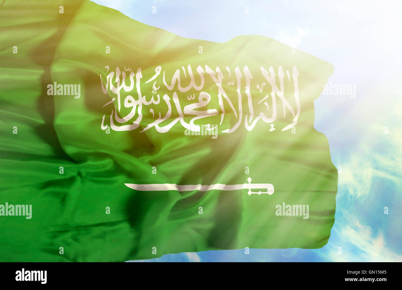 Saudi Arabia waving flag against blue sky with sunrays Stock Photo - Alamy