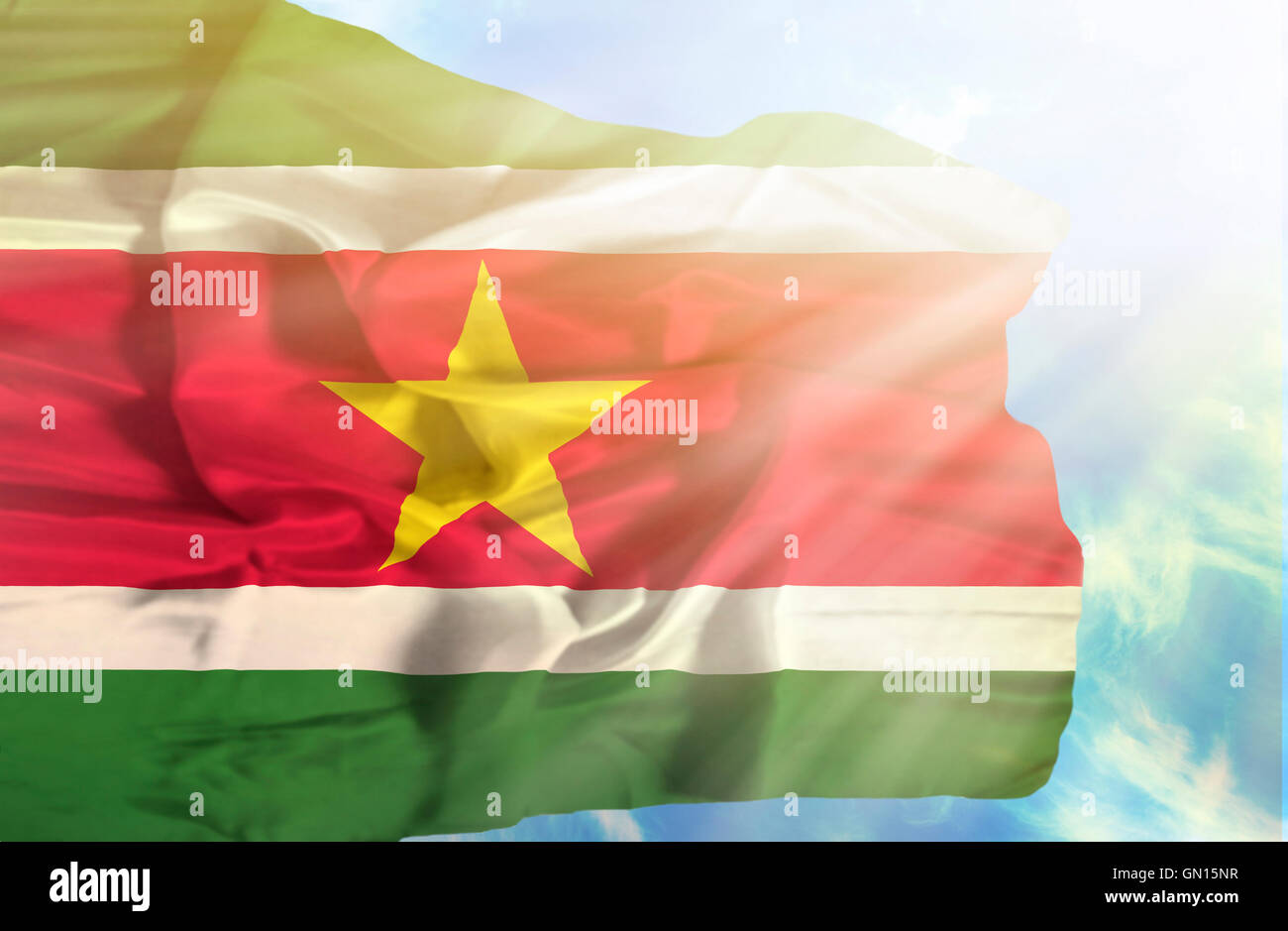 Suriname waving flag against blue sky with sunrays Stock Photo - Alamy