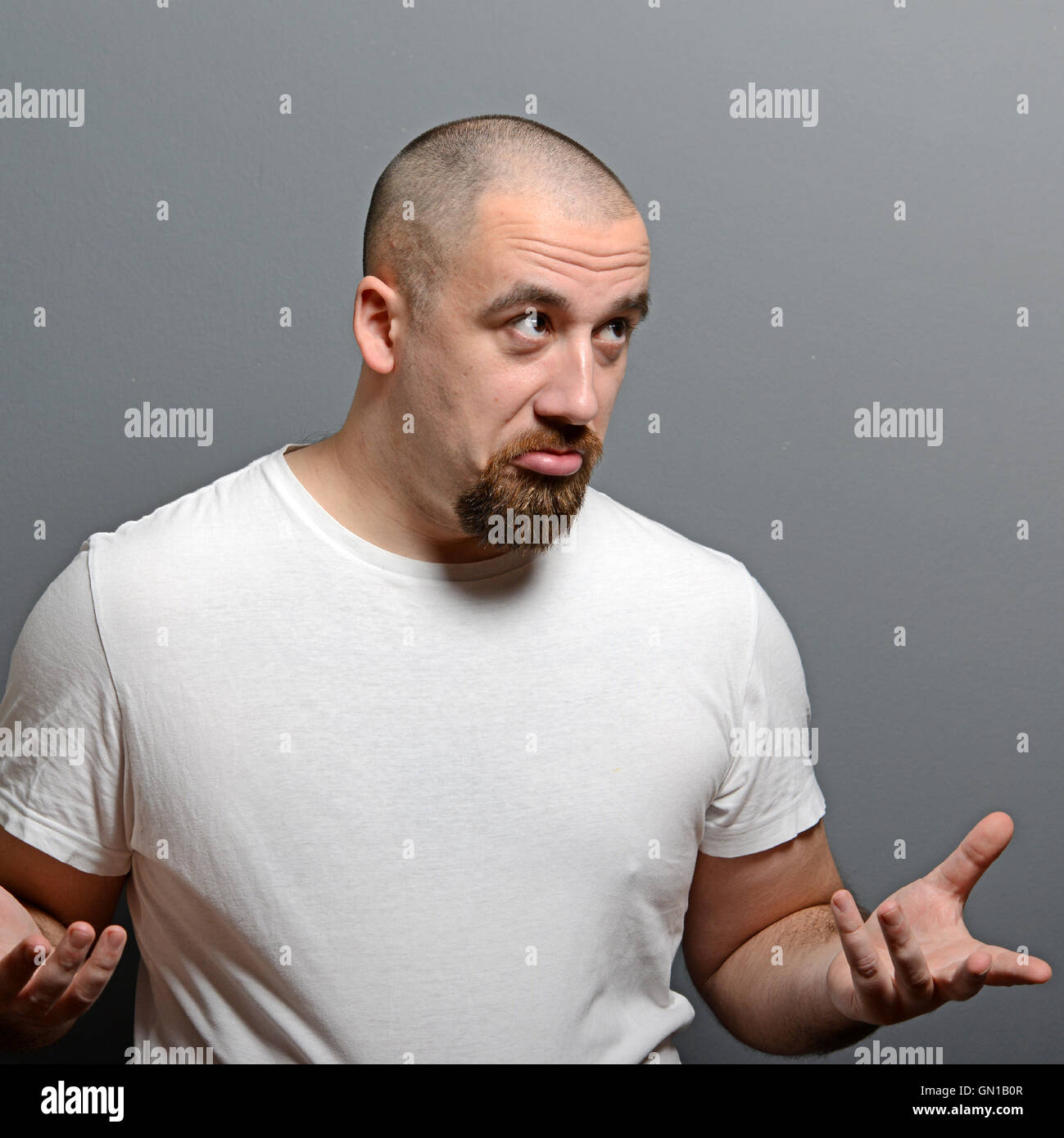 Portrait of a confused man against gray background Stock Photo - Alamy