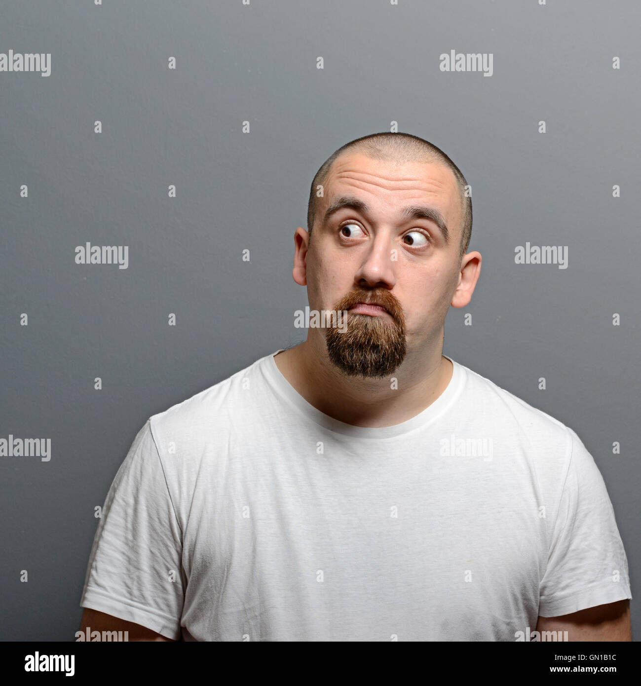 Portrait of a confused man against gray background Stock Photo - Alamy
