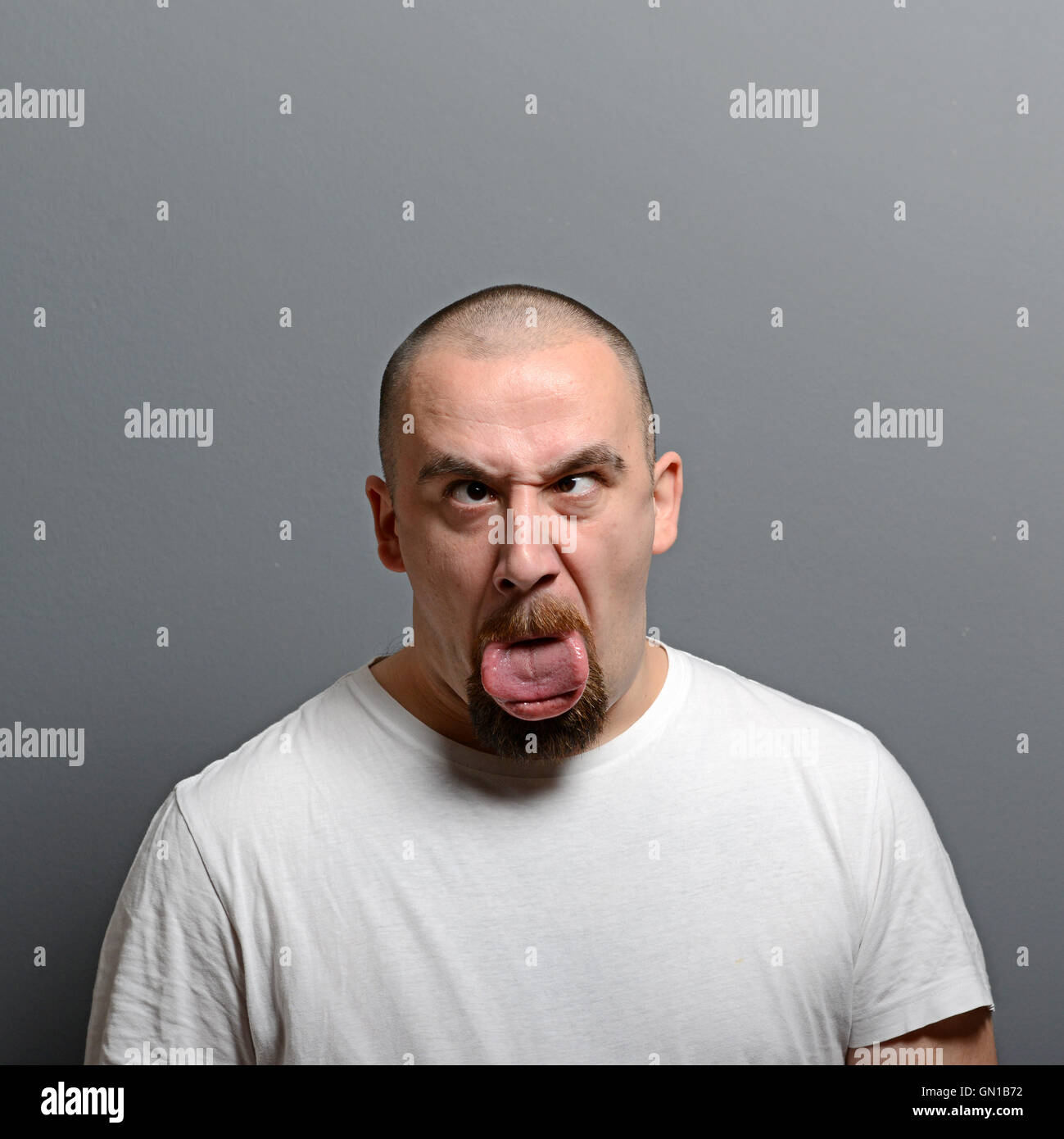 Portrait of a man making funny face against gray background Stock Photo ...