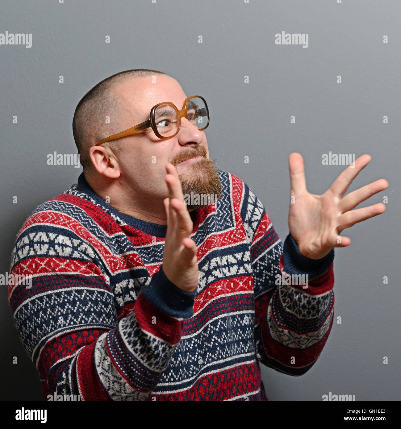 Portrait of a nerd clapping hands with glasses and retro sweater ...