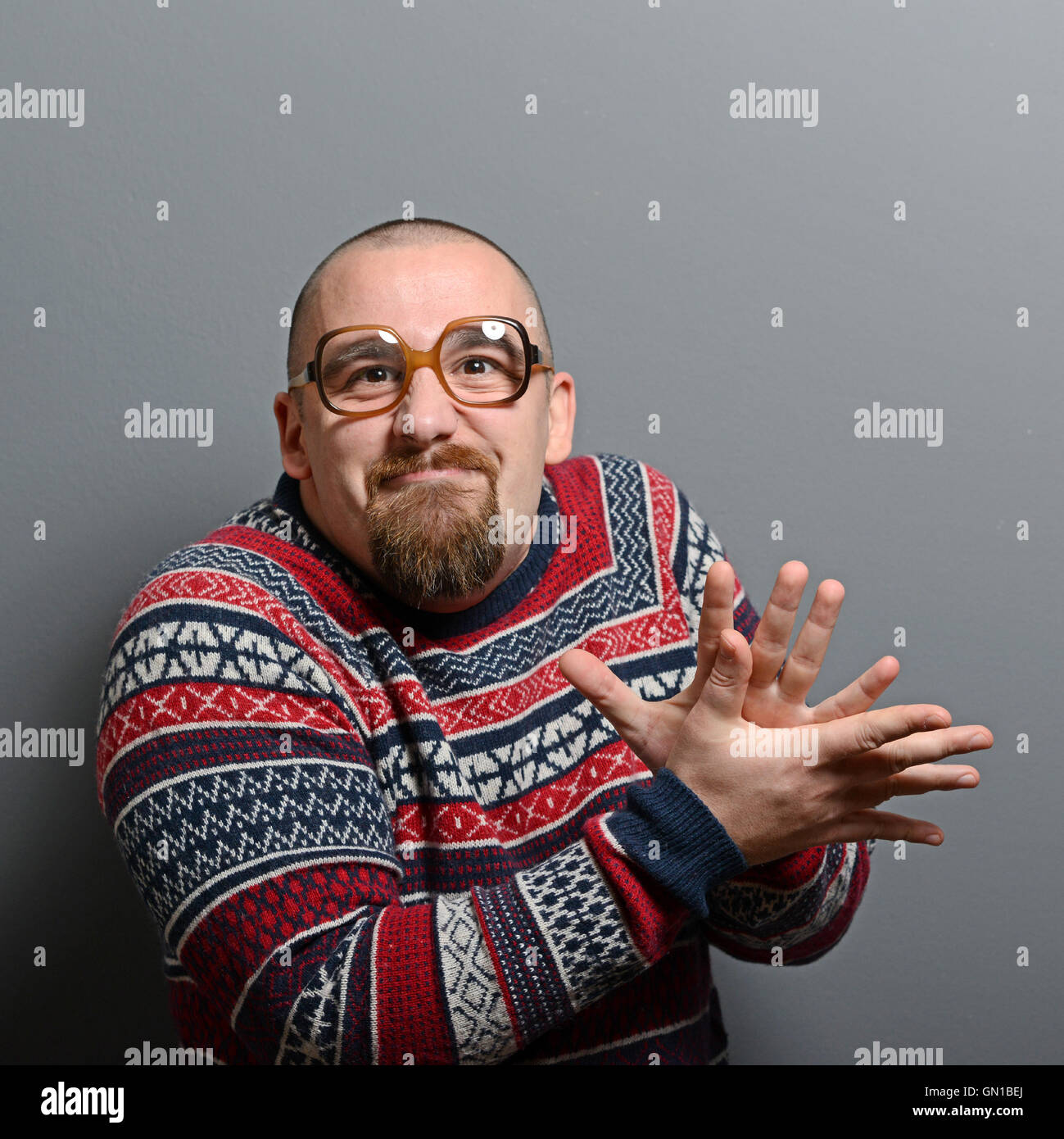 Portrait of a nerd clapping hands with glasses and retro sweater ...