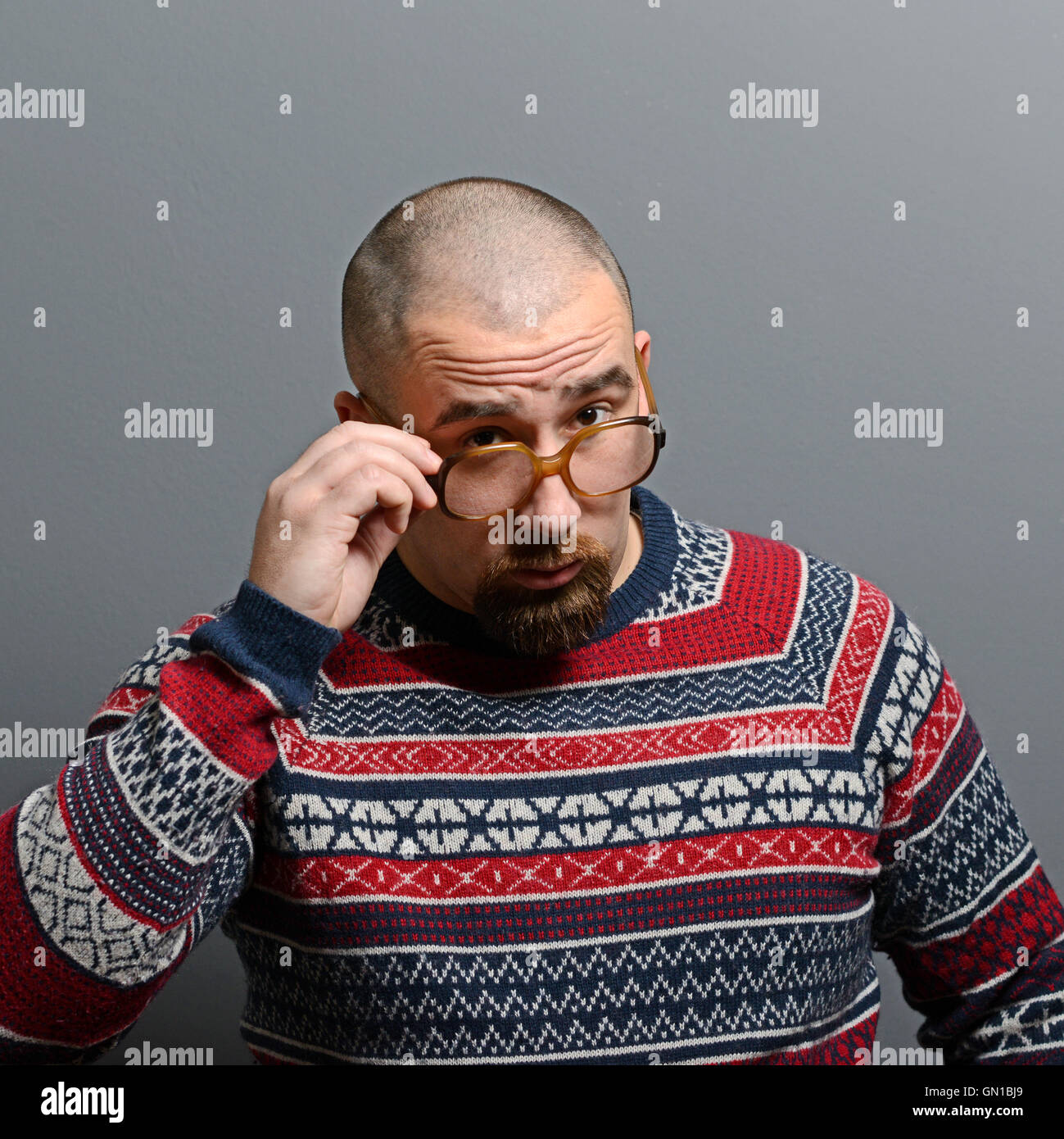Portrait of a nerd with glasses and retro sweater against gray ...