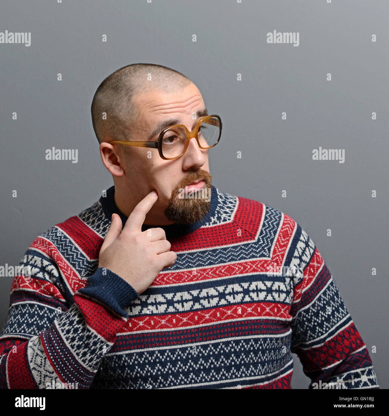 Portrait of a nerd with glasses and retro sweater against gray ...