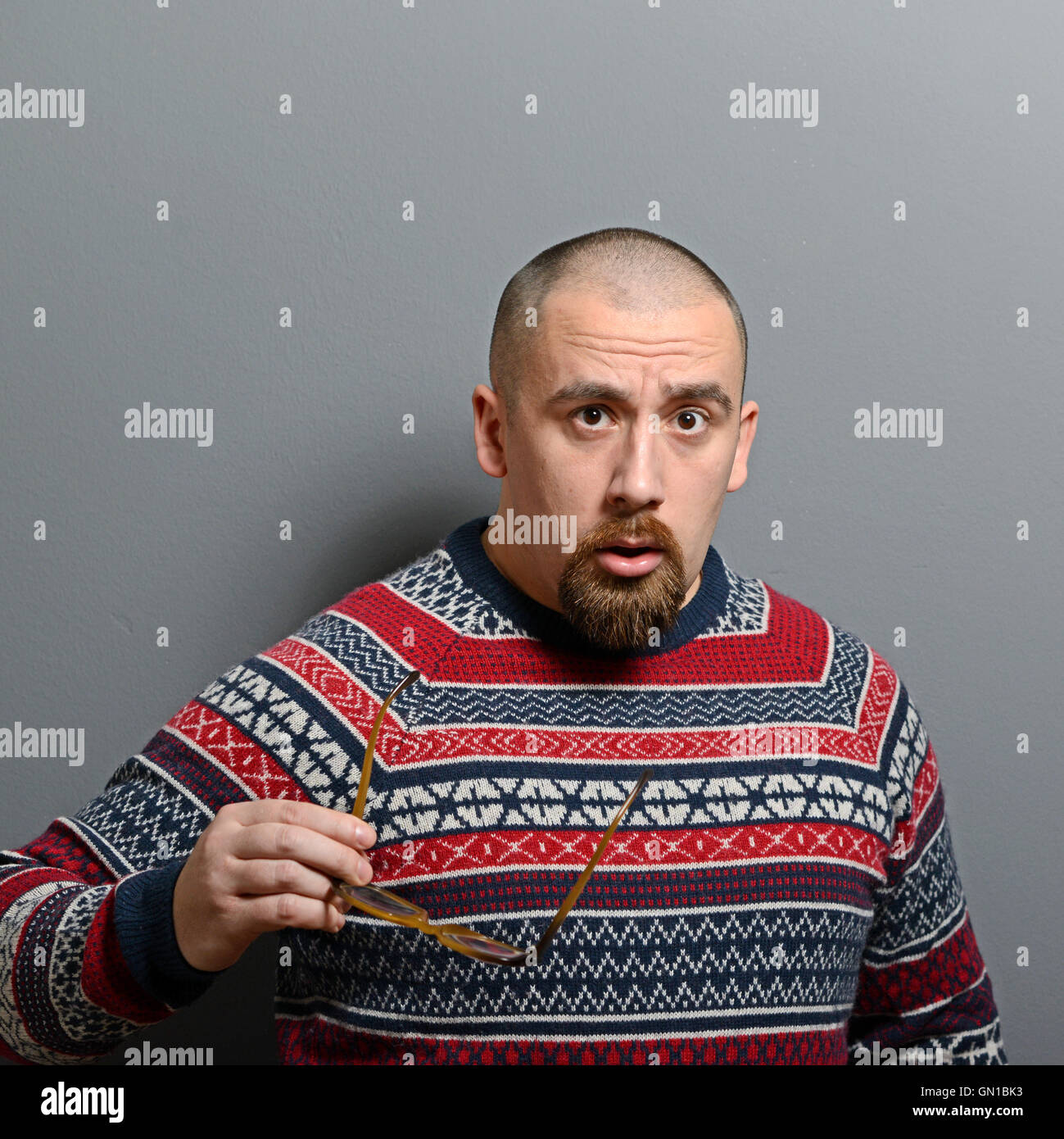 Portrait of a nerd with glasses and retro sweater against gray ...