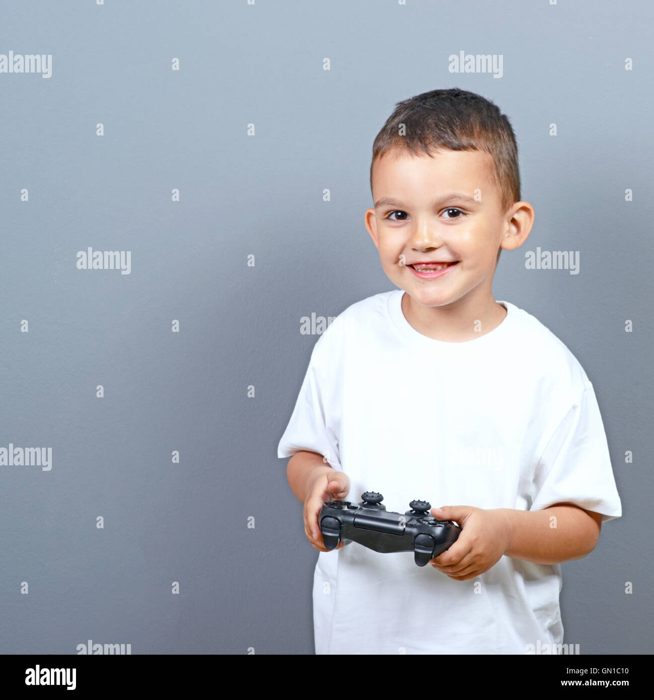 Cute little boy kid holding joystick and playing video games against ...