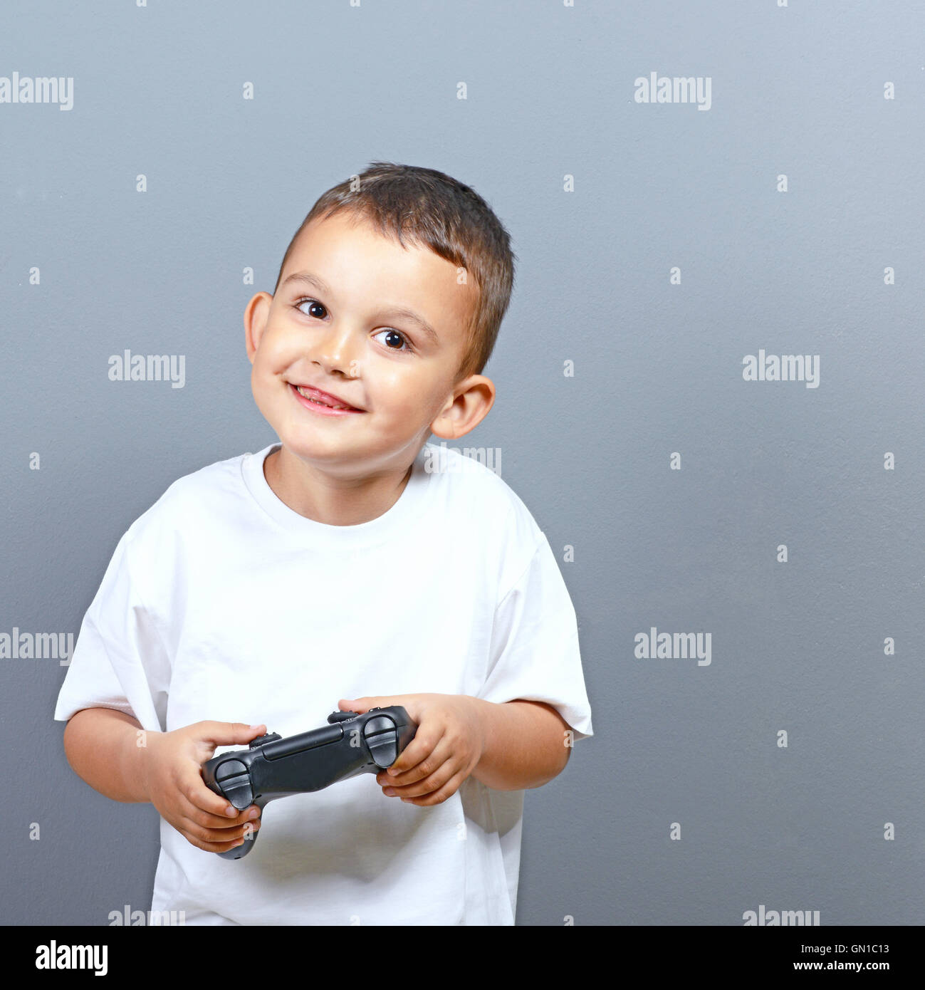 Cute little boy kid holding joystick and playing video games against ...