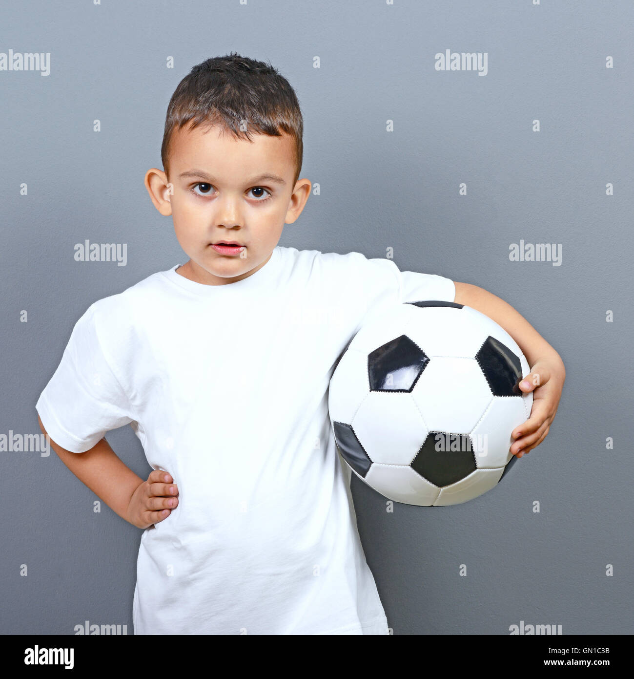 Cute little boy kid posing with football against gray background Stock ...